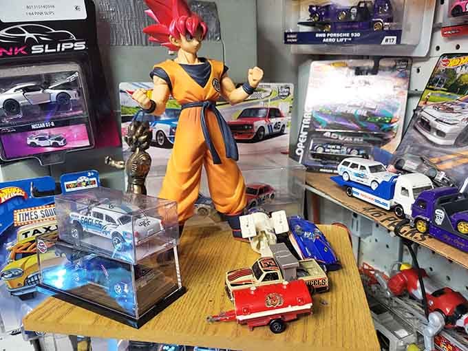 That action figure stands guard over die-cast cars like a tiny superhero protecting a very specific kind of automotive treasure.