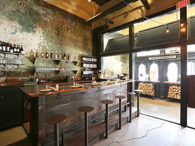 The bar area with its rustic wood and stacked firewood reminds you this is serious wood-fired territory, friends.