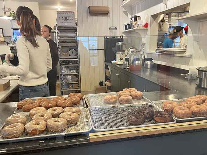 Behind the scenes where the magic happens, fresh donuts cooling on racks like edible works of art awaiting their debut.