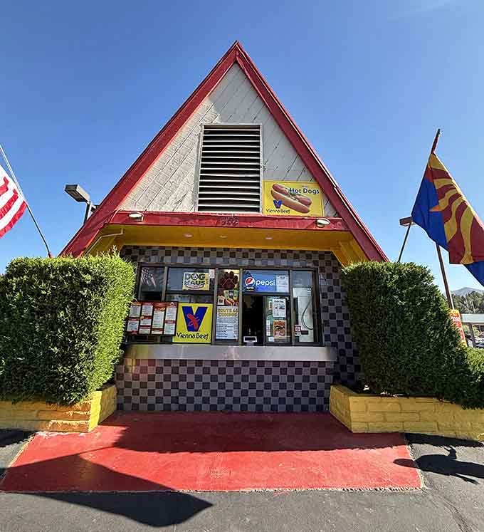 The ordering window where hot dog dreams come true, framed by cheerful yellow and classic roadside charm.
