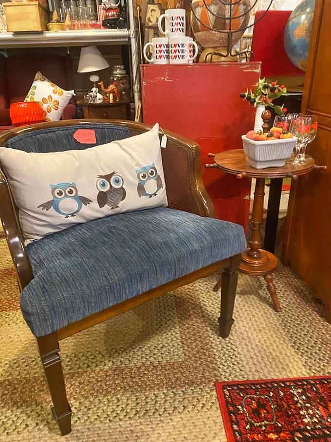 An owl-print pillow on a vintage chair proves that quirky home decor existed long before Pinterest claimed it.