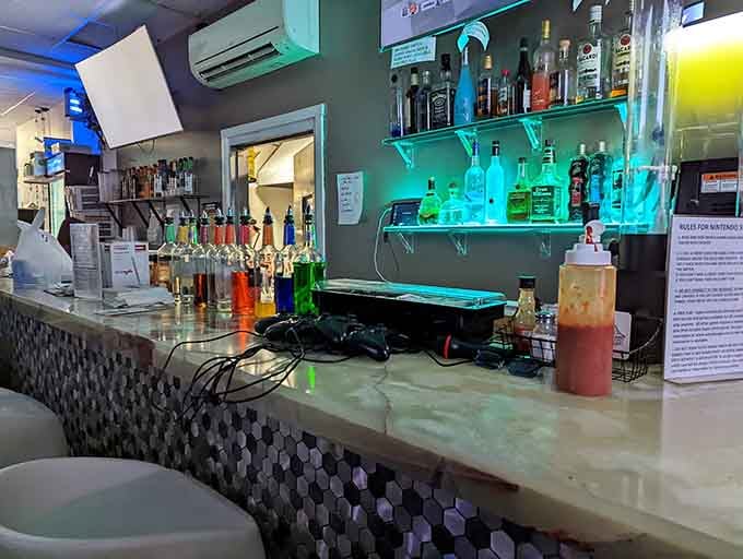 A full bar with neon lighting means parents can relax while kids game, creating everyone's ideal dining scenario.