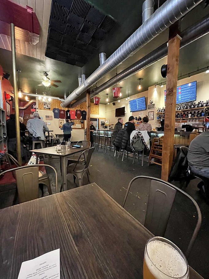 Exposed ductwork and warm lighting create the kind of atmosphere where strangers become friends over good beer.