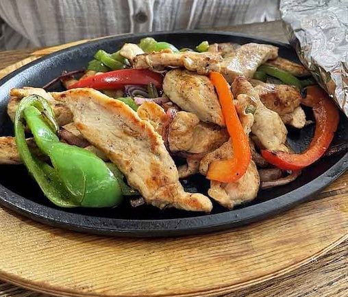 Sizzling fajitas arriving at your table like a Broadway show, complete with steam and drama.