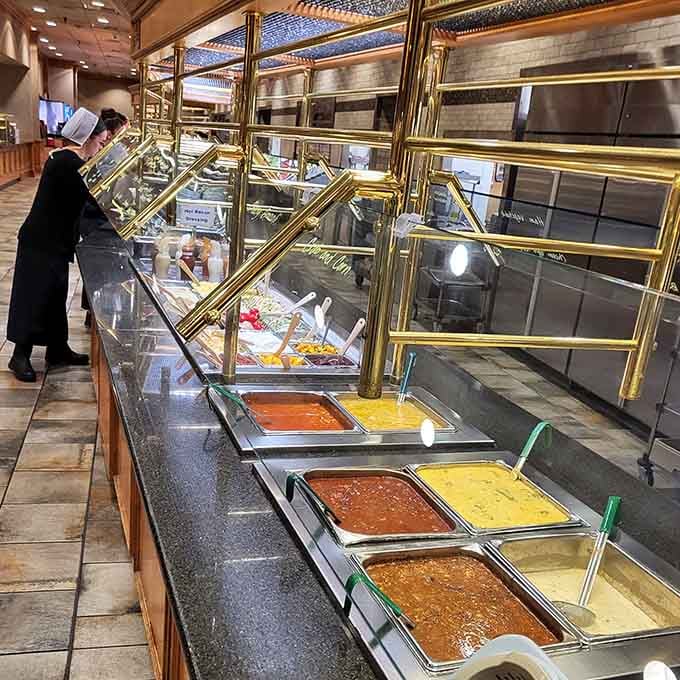 Buffet stations gleaming with promise, those brass rails protecting more food than most people see in a week.