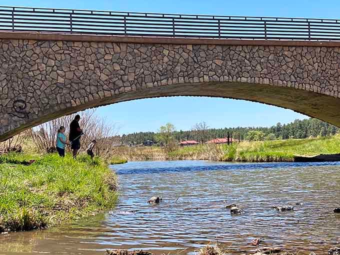 Families fish together under stone bridges at local lakes, creating Norman Rockwell moments that still happen in real life.
