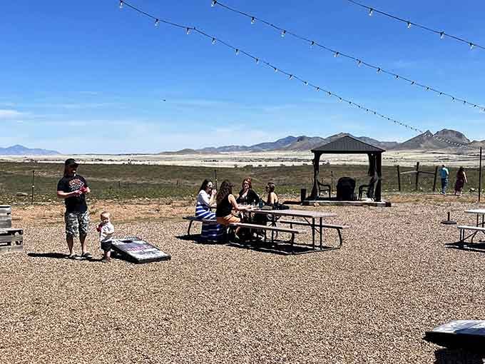 Families gathering under dramatic skies with picnic tables and wine: the Arizona wine country experience in action.