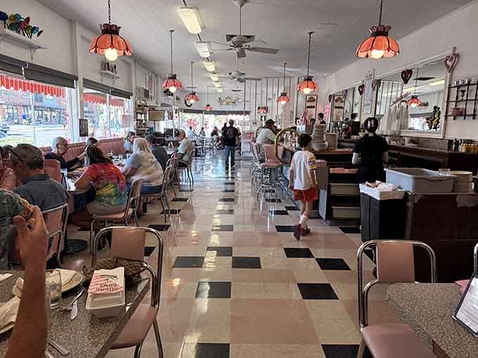 Multiple generations sharing tables and sundaes, creating memories one scoop at a time in this timeless space.