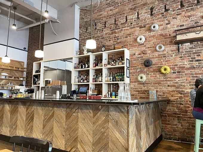 Exposed brick and herringbone wood paneling create a bar area that's equally perfect for solo dining or catching up with friends.
