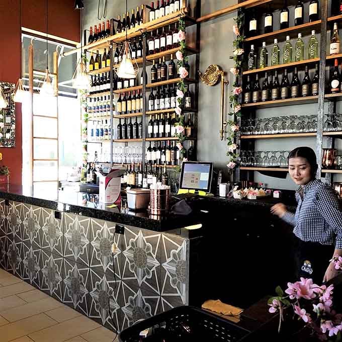 The bar area gleams with bottles and possibilities, ready to complement your meal with perfect pairings.