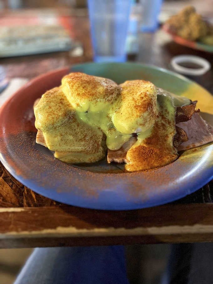 Eggs Benedict with hollandaise so rich it deserves its own tax bracket, served on a colorful plate of pure joy.