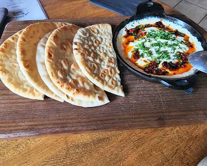 Baked goat cheese with warm pita bread delivers Mediterranean vibes straight to your Louisville dinner table tonight.