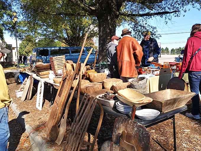 Vintage wooden bowls and rustic treasures under autumn leaves create an outdoor gallery of functional folk art.