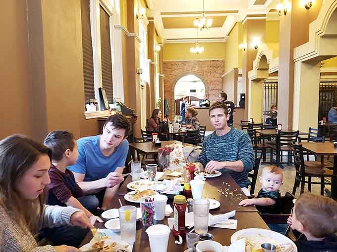 Families gathering around tables in a historic space, making memories one breakfast plate at a time together.