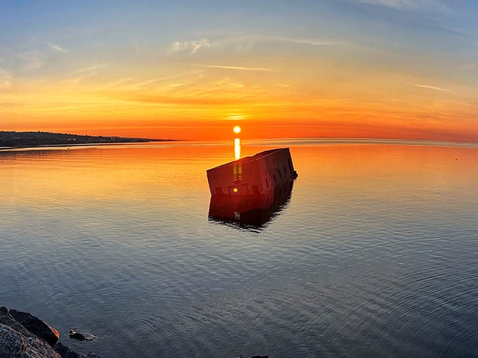 Sunset paints the structure in fiery oranges and reds, making it look less like ruins and more like lakeside poetry.