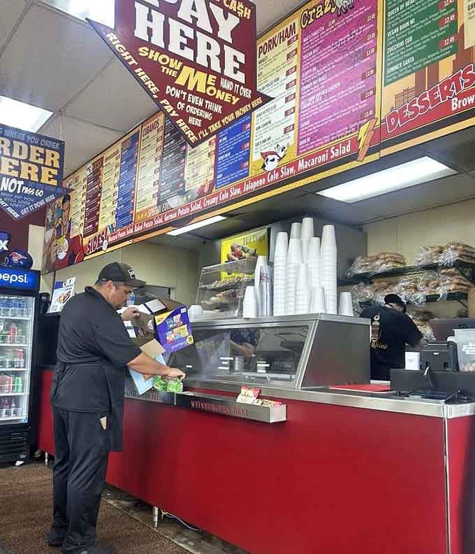 Behind that counter, the staff works their magic turning simple ingredients into towering masterpieces of sandwich architecture.