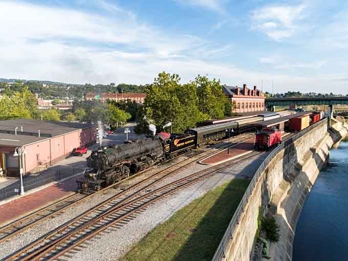 The steam locomotive rests at the station as golden hour light hits, looking ready for its close-up.