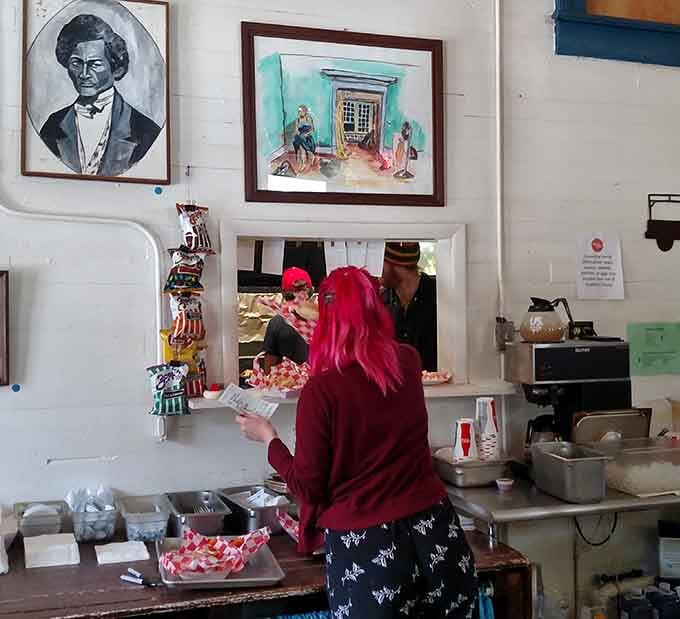 The order counter where culinary magic begins, framed by eclectic art and a whole lot of character.