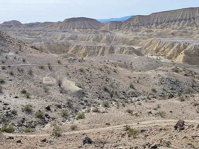 The surrounding badlands stretch endlessly, looking like Earth's wrinkled skin telling stories millions of years old.
