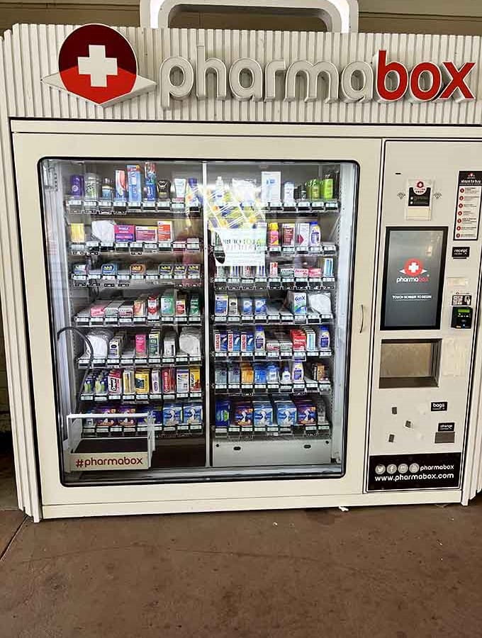 A pharmabox vending machine stands ready for shopping emergencies, because blisters and headaches don't respect your retail marathon schedule at all.