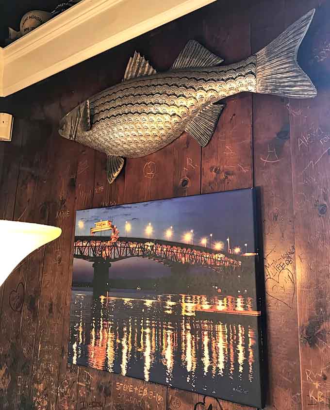 A metal fish watches over diners while bridge photography reminds you that waterfront towns have the best stories.