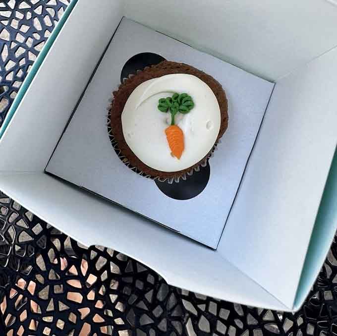 A carrot cake cupcake topped with an adorable fondant carrot, proving vegetables can be dessert when properly motivated.