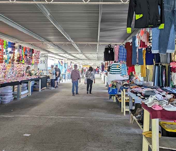 Metal roofing shelters endless aisles of clothing and household goods while natural light filters through, making everything look surprisingly Instagram-worthy.
