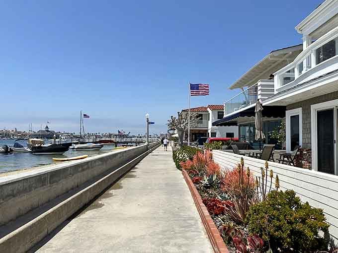 Charming waterfront homes and blooming planters line this sunny promenade where boats and bay views steal the show.