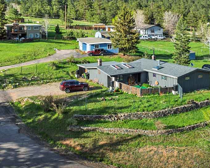 Green meadows roll between scattered homes where country living meets mountain views in perfect harmony.