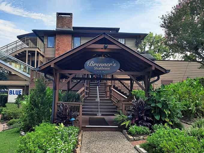 The wooden entrance surrounded by palms and greenery promises an escape—steak dinner meets secret garden along the bayou.