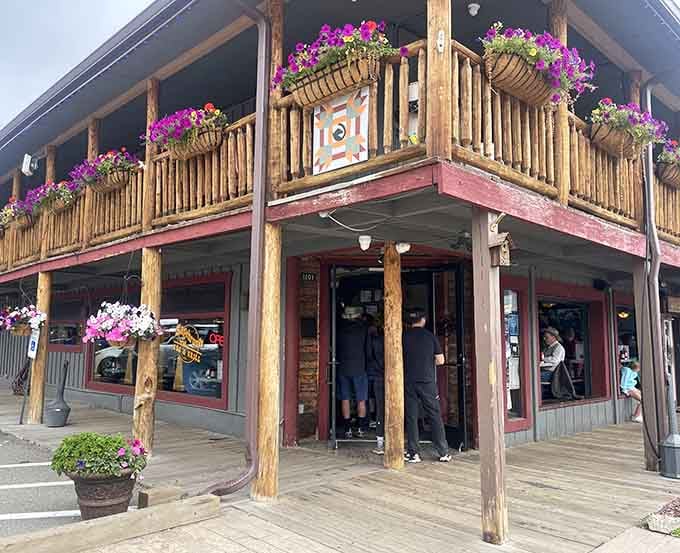 Rustic wooden balconies overflow with purple petunias, welcoming mountain visitors to hearty barbecue and genuine small-town hospitality.