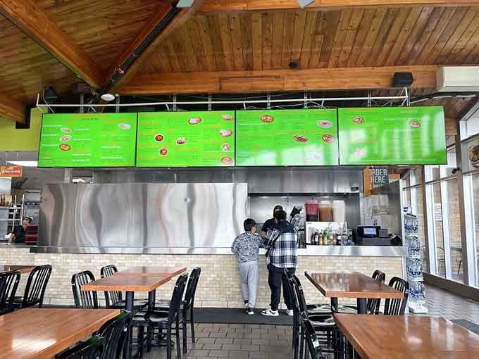 Simple tables, vaulted wood ceiling, and that massive green menu board &ndash; everything you need, nothing you don't.