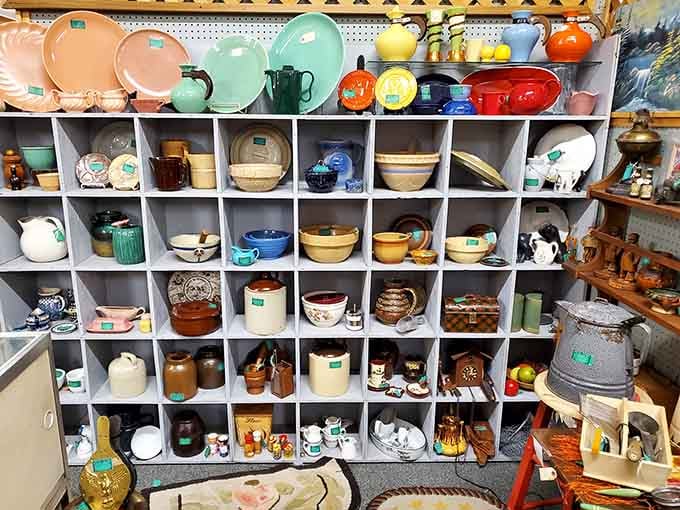 Cubbies filled with colorful pottery and ceramics, a rainbow of kitchenware from when dishes had personality.