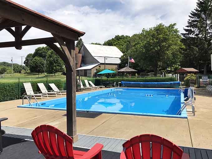 The pool area with red chairs invites you to relax poolside like you're at a resort, just cheaper.