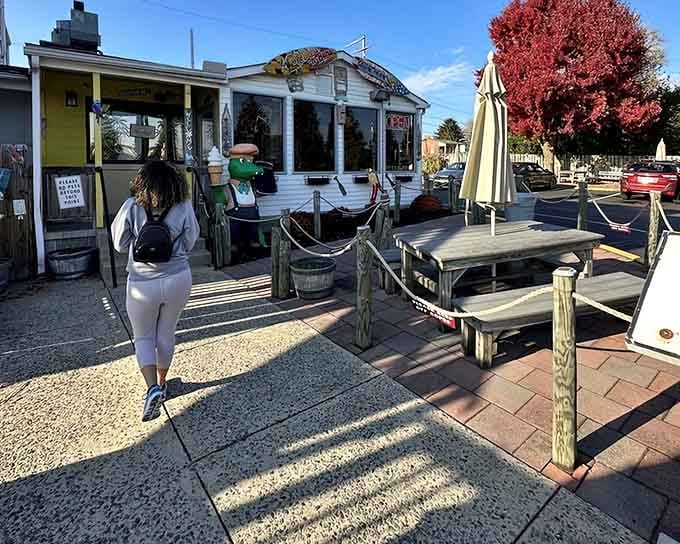 The outdoor patio beckons with picnic tables and tropical vibes, perfect for savoring burgers under blue skies and sunshine.