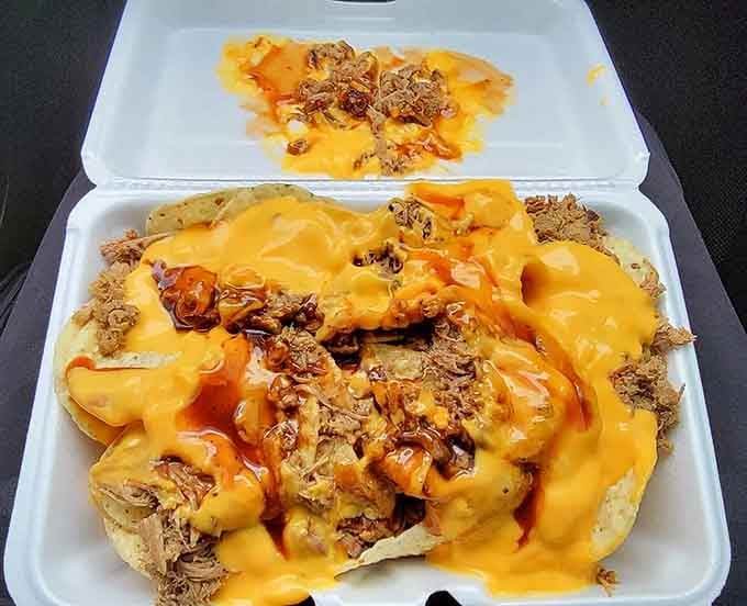 Pulled pork nachos drowning in melted cheese represent the kind of brilliant fusion that makes you wonder why everywhere doesn't do this.
