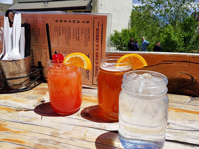 Mason jar drinks with orange slices catching Arizona sunshine, because even beverages deserve a mountain view.