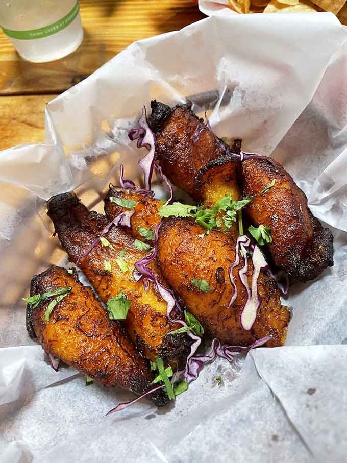 Sweet plantains caramelize into golden perfection, offering that natural sweetness that pairs beautifully with any savory dish on the menu.