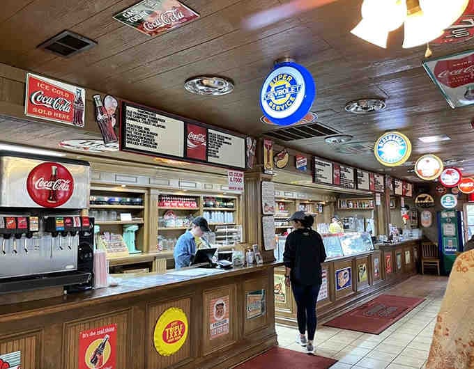 The ordering counter where vintage Coca-Cola signs meet modern appetites, creating the perfect blend of past and present dining experiences.