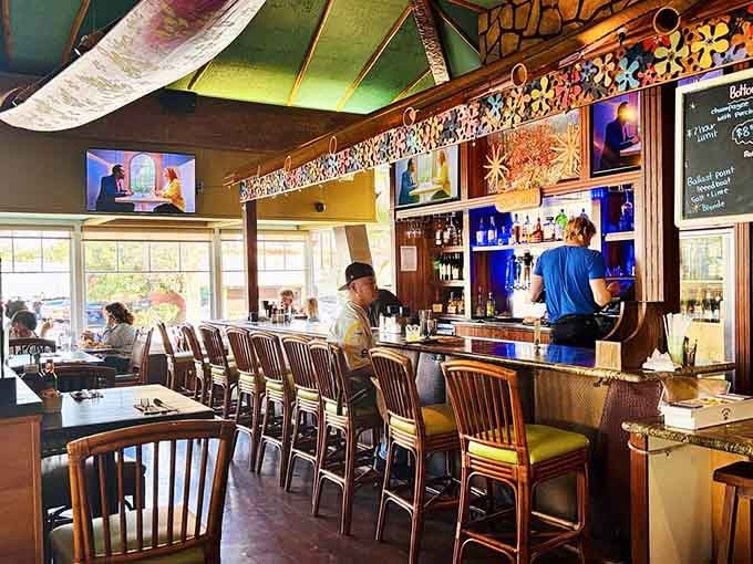 The bar area glows with backlit bottles and island charm, where bartenders mix drinks that actually taste like the tropics.