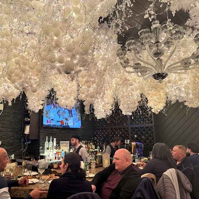 Cascading white blossoms create a floral canopy over the bar that feels like springtime decided to stay forever.
