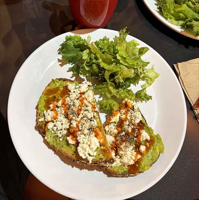 Avocado toast elevated with feta and hot sauce, because even themed coffee shops know how to do brunch right.
