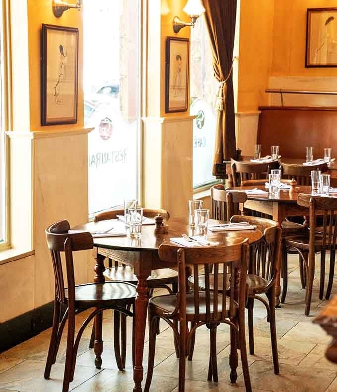 Sunlight streaming through windows onto empty tables just waiting for you to claim one for your French feast.