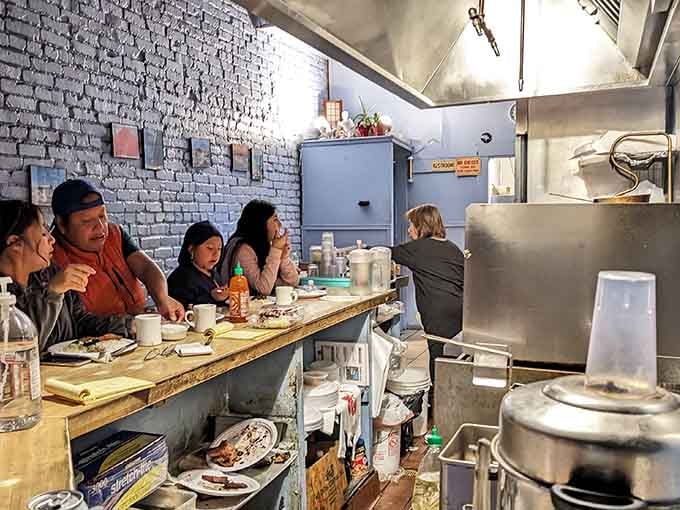 Diners at the counter experiencing what regulars have known forever: this is where the real magic happens.