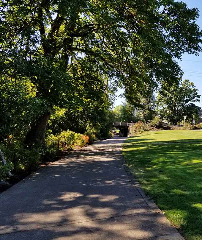 The paved trail meanders through mature trees and manicured lawns, making exercise feel suspiciously like a pleasant stroll.