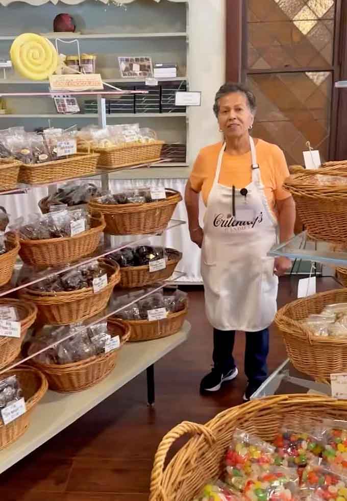 The friendly staff member surrounded by baskets of candy, living the dream we all secretly wish we had chosen.