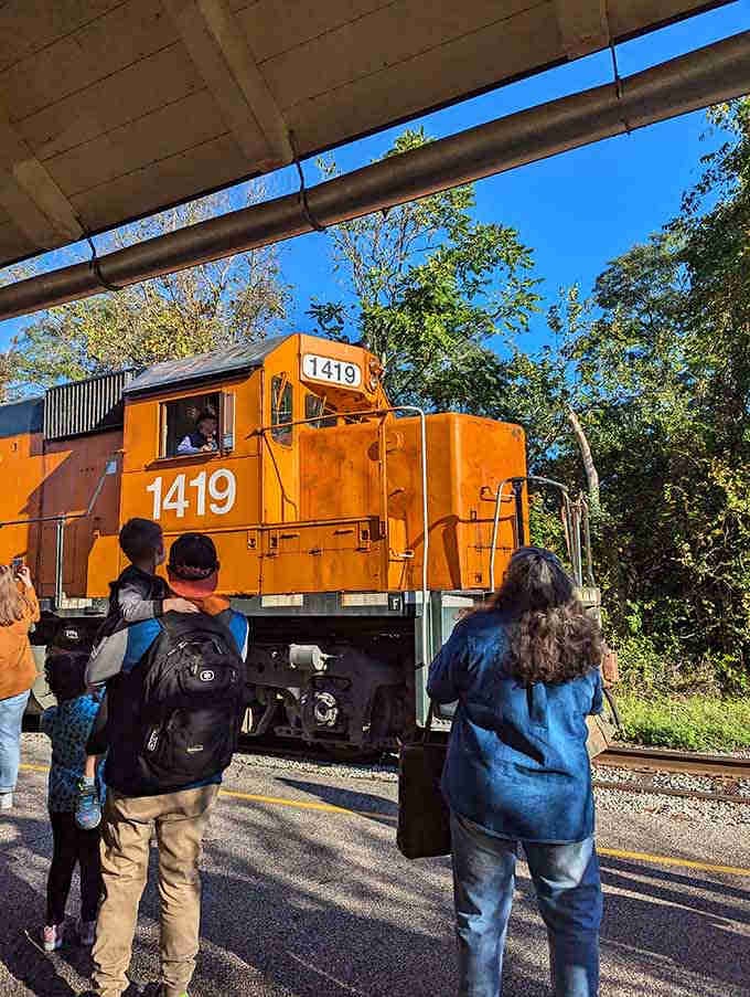 Passengers gather in anticipation, proving that train travel still captures imaginations across all generations beautifully.