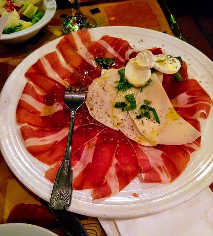 Prosciutto and fresh mozzarella arranged like edible art—this appetizer deserves its own museum exhibit, honestly.
