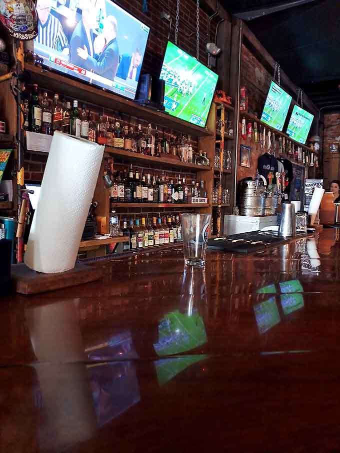 Polished wood bar reflecting multiple TV screens and endless bottle selections is where magic happens nightly.