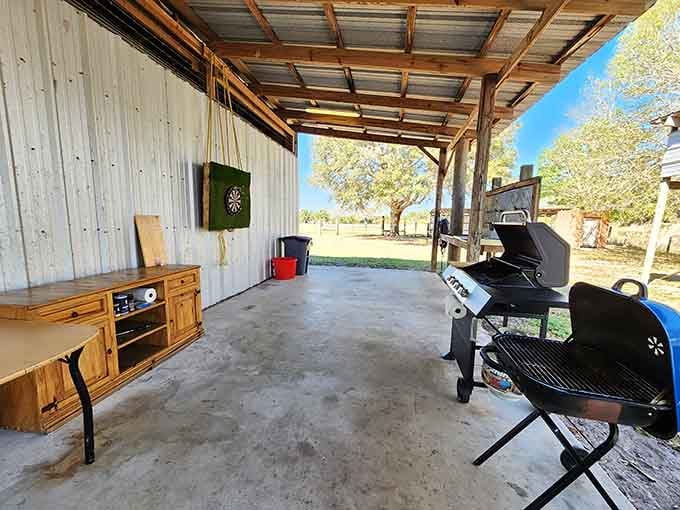 An outdoor kitchen setup complete with grill and dartboard because multitasking is a vacation skill worth mastering.